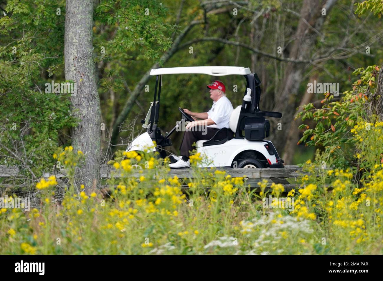 Former President Donald Trump rides around his golf course at Trump ...