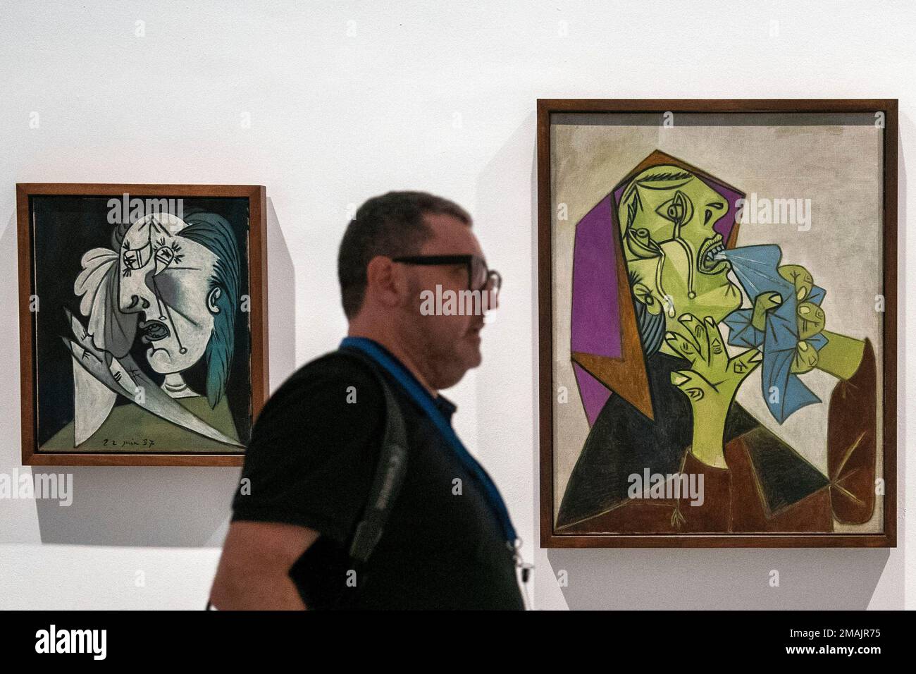 A man walks past two paintings by Pablo Picasso after a news conference ...