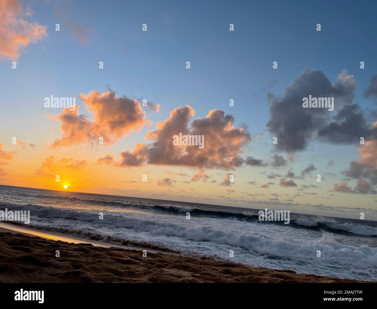A beach with a sea in the background during scenic bright sunset Stock ...