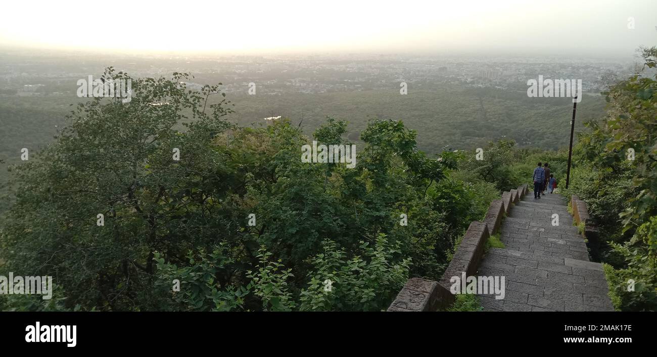 A beautiful panoramic view of trees on a hill with people going down ...