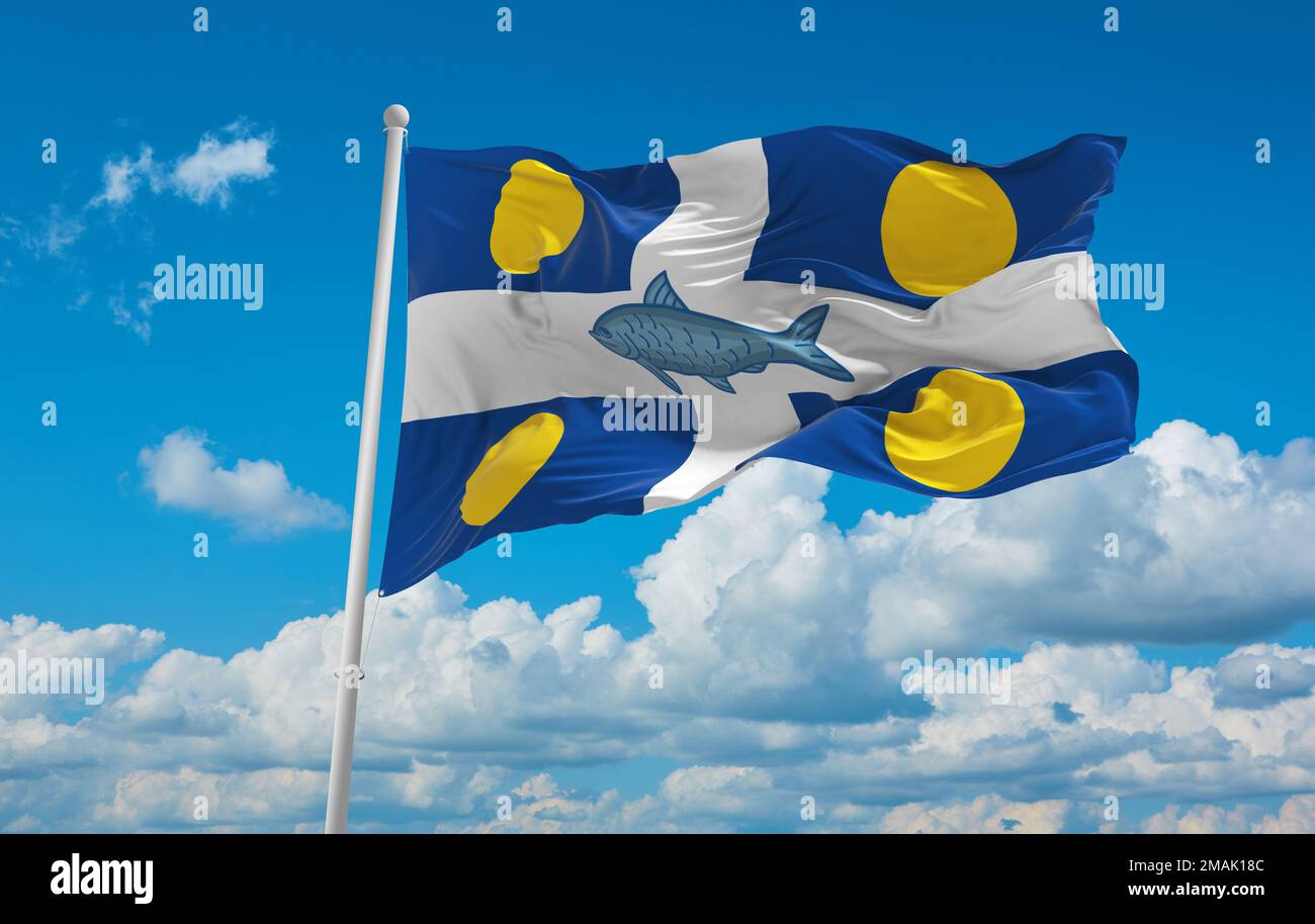 official flag of Fortune, Newfoundland and Labrador Canada at cloudy sky background on sunset ...