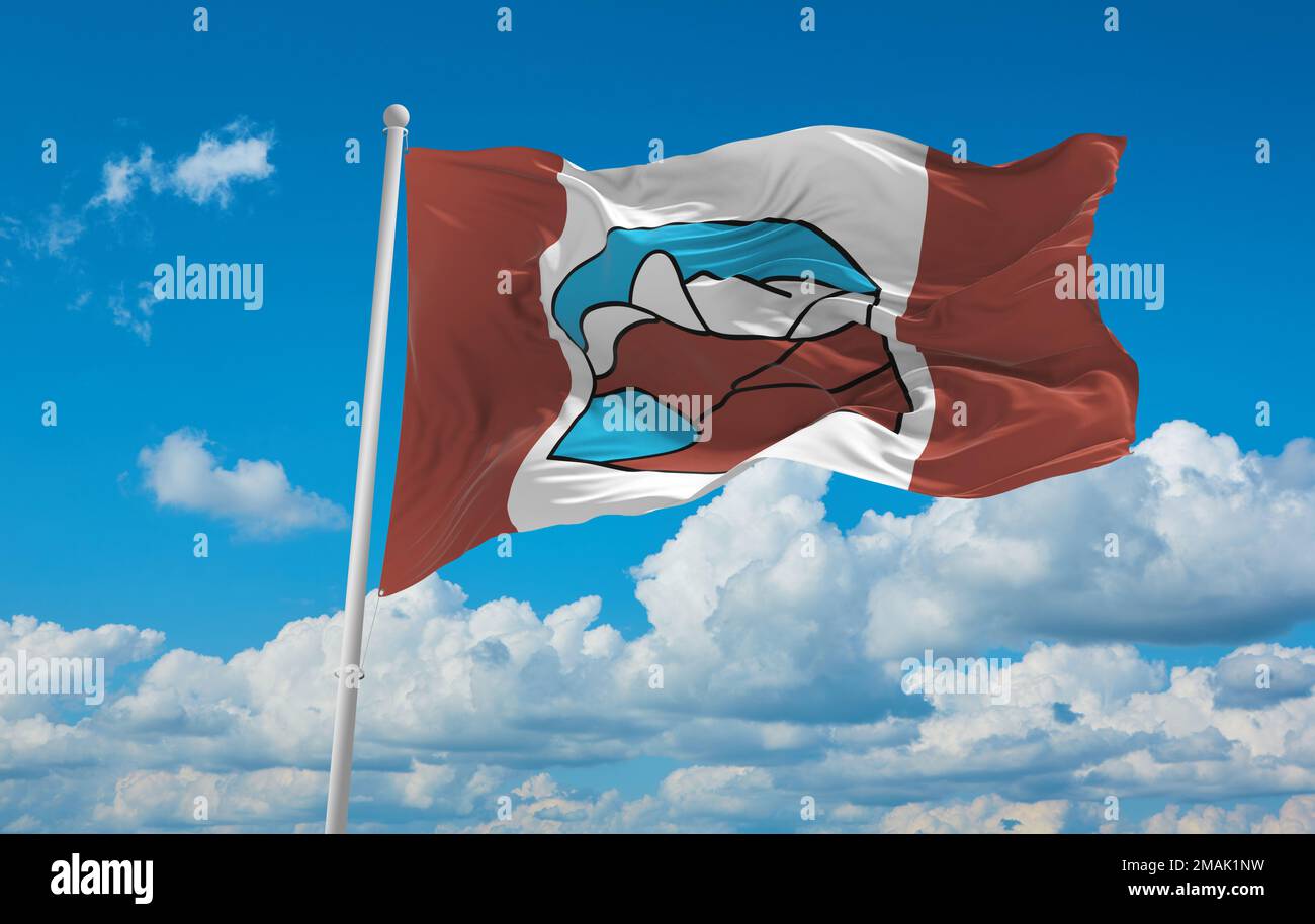 official flag of Grise Fiord, Nunavut Canada at cloudy sky background ...