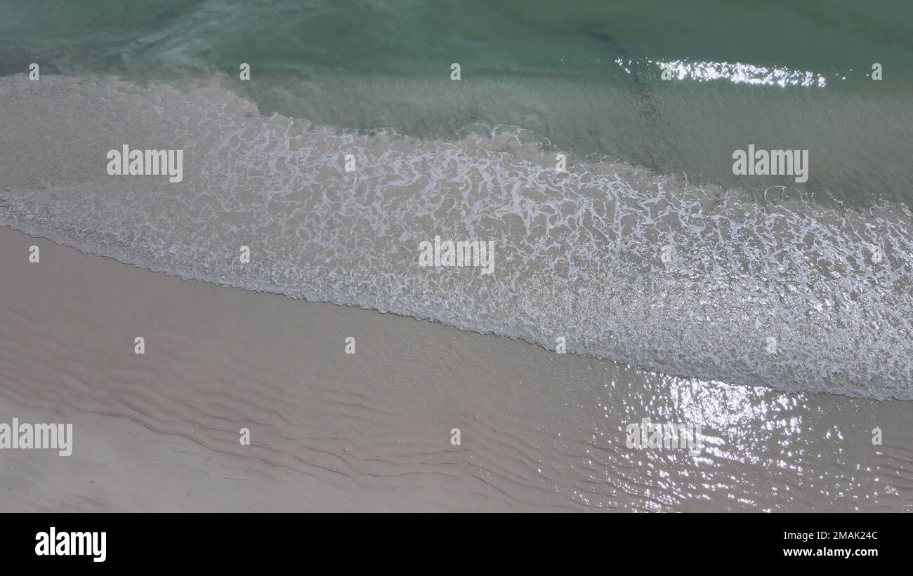 An aerial view of foamy sea waves washing up onto a shore Stock Photo ...