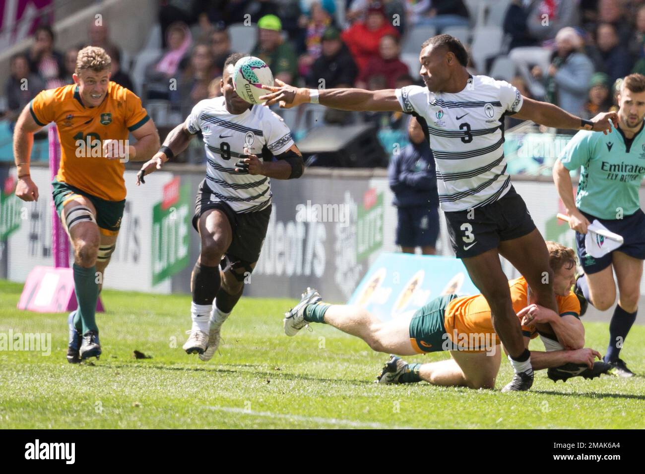 Jeremaia Matana of Fiji passes the ball as he is tackled by Henry ...