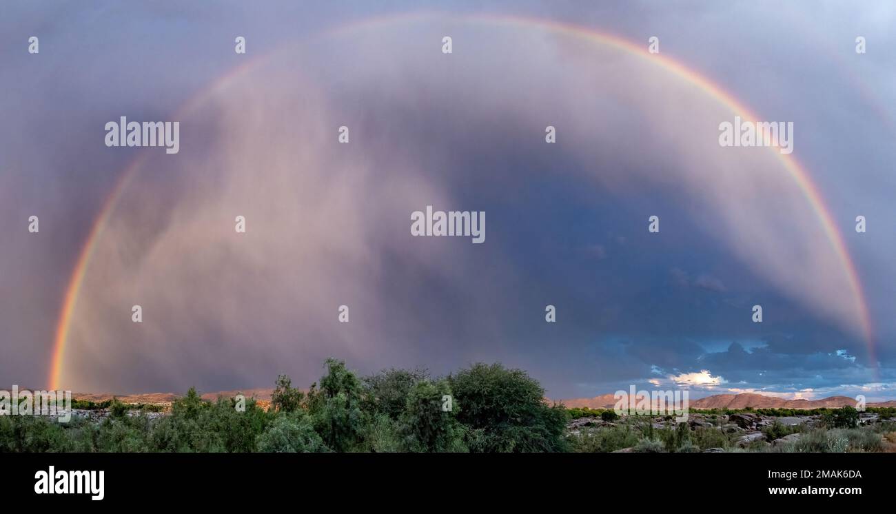 A complete rainbow under storm clouds. Augrabies Falls National Park ...
