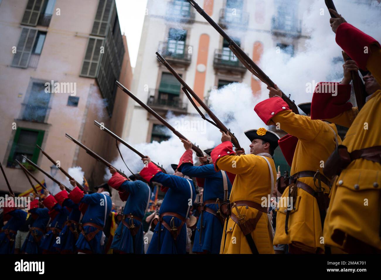 Men dressed in costume shoot their rifles during a performance to ...