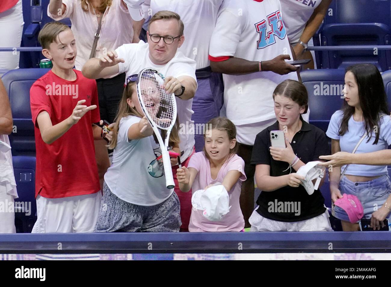 Fans get the racket of Iga Swiatek, of Poland, after she defeated Ons ...