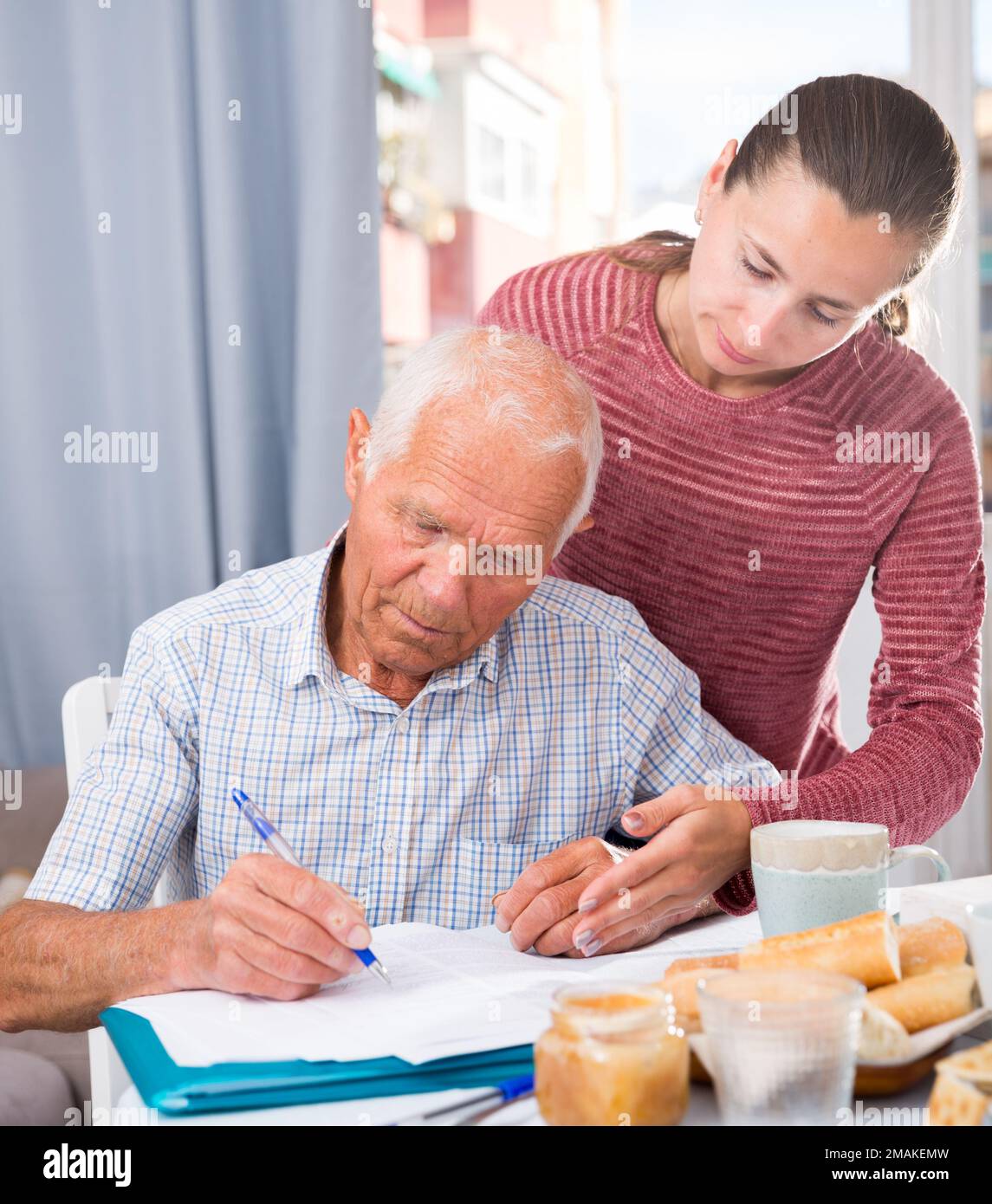 Mature father and adult daughter fill out paperwork Stock Photo - Alamy