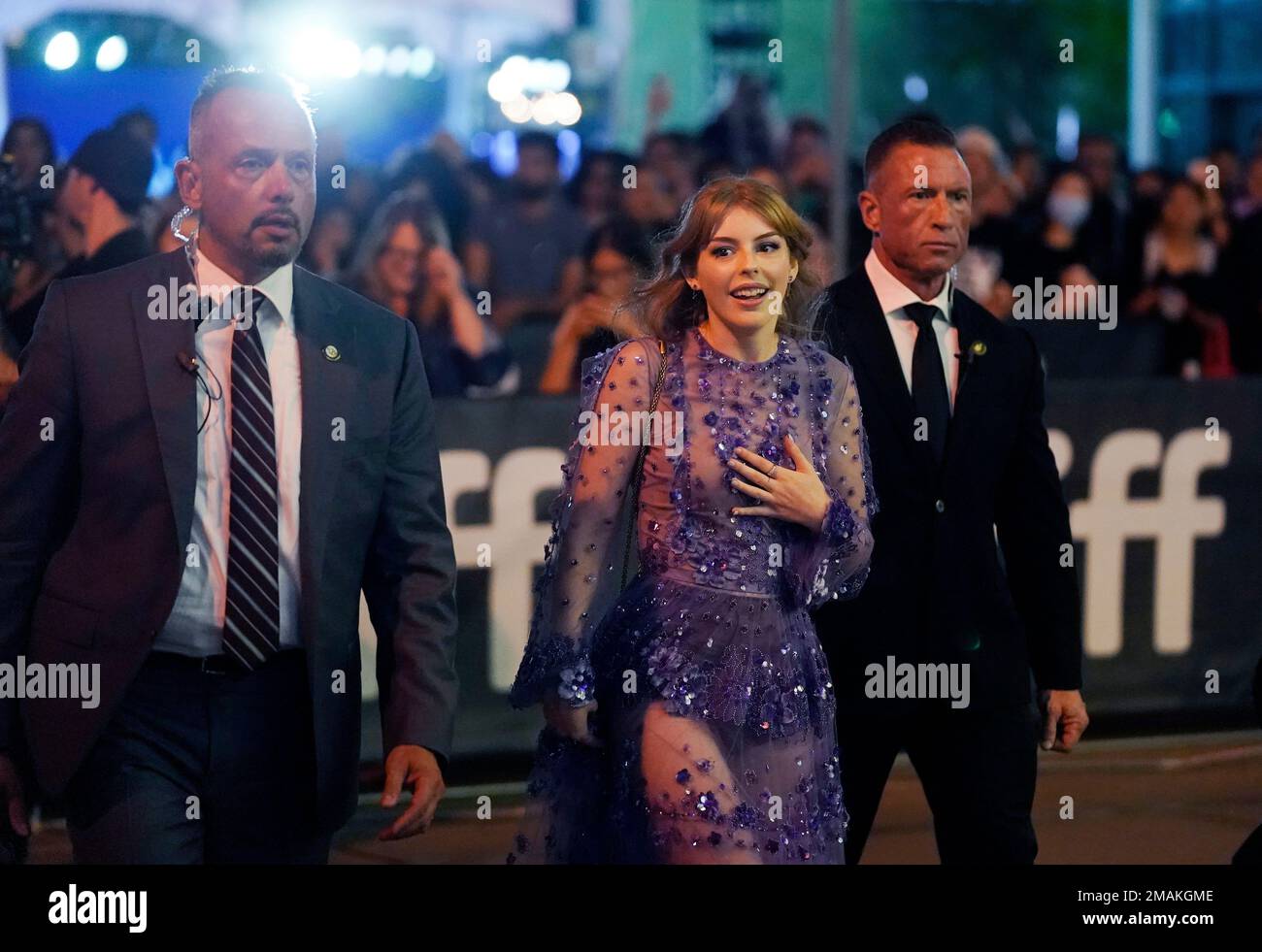 Amelia Gething, a cast member in "Emily," is led to the red carpet by ...