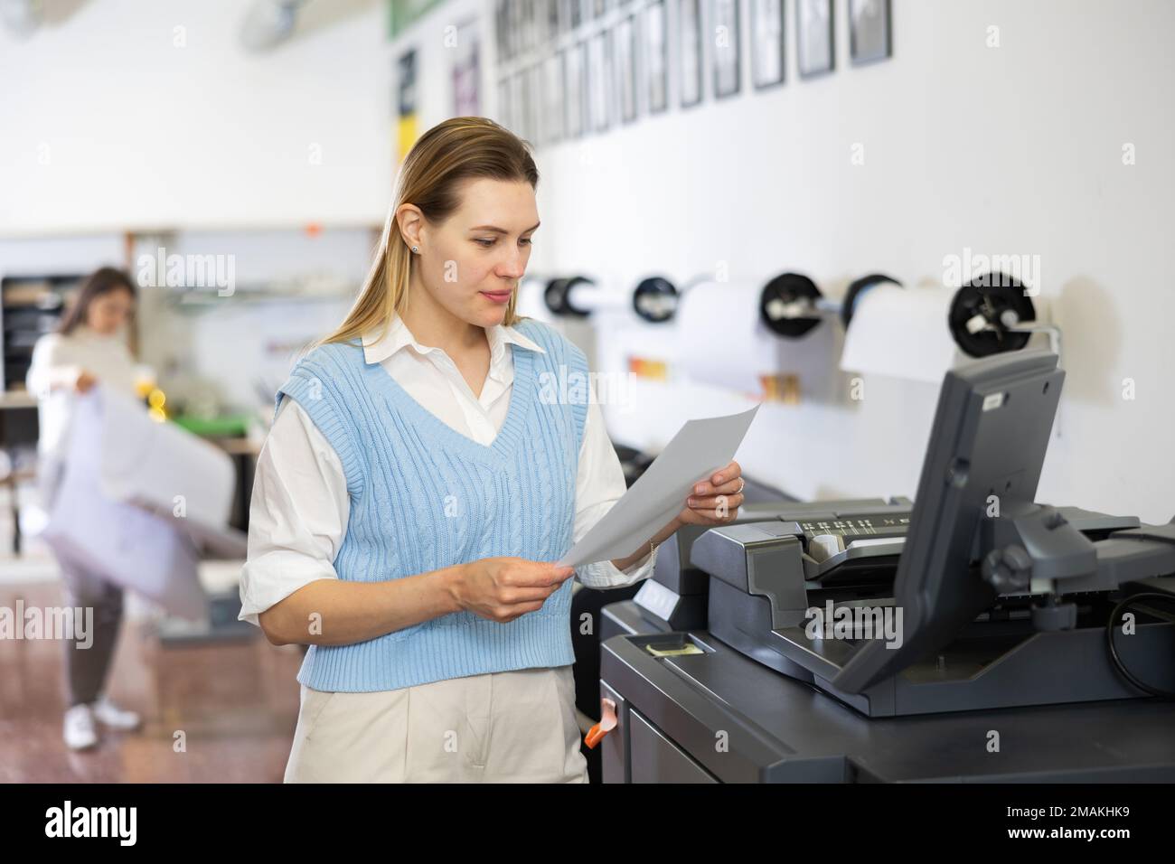 Technician operator calibrating plotter machine, typing on computer ...