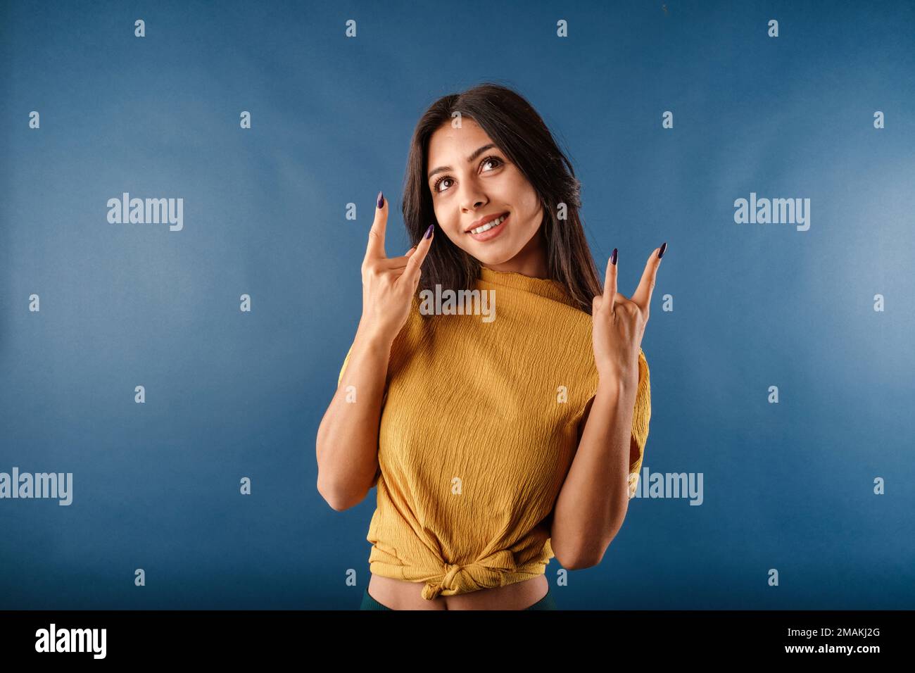 Young woman smiling confident wearing mustard yellow t-shirt isolated ...