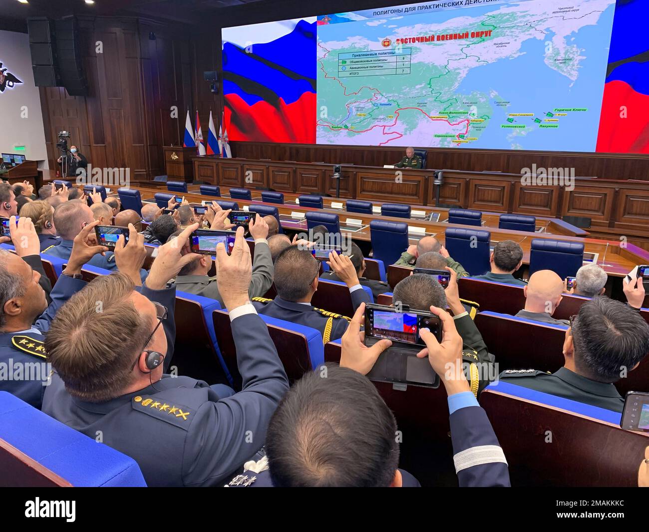 Foreign military attachés take photos of screen showing Vostok 2022 military exercise as Russian ...
