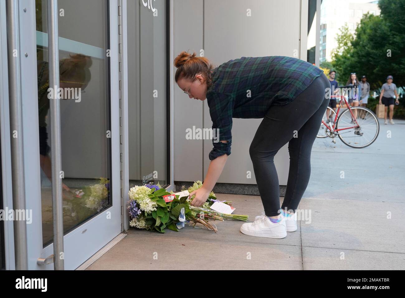 Sam Stanley, of Medford, Mass., places flowers near an entrance to the ...