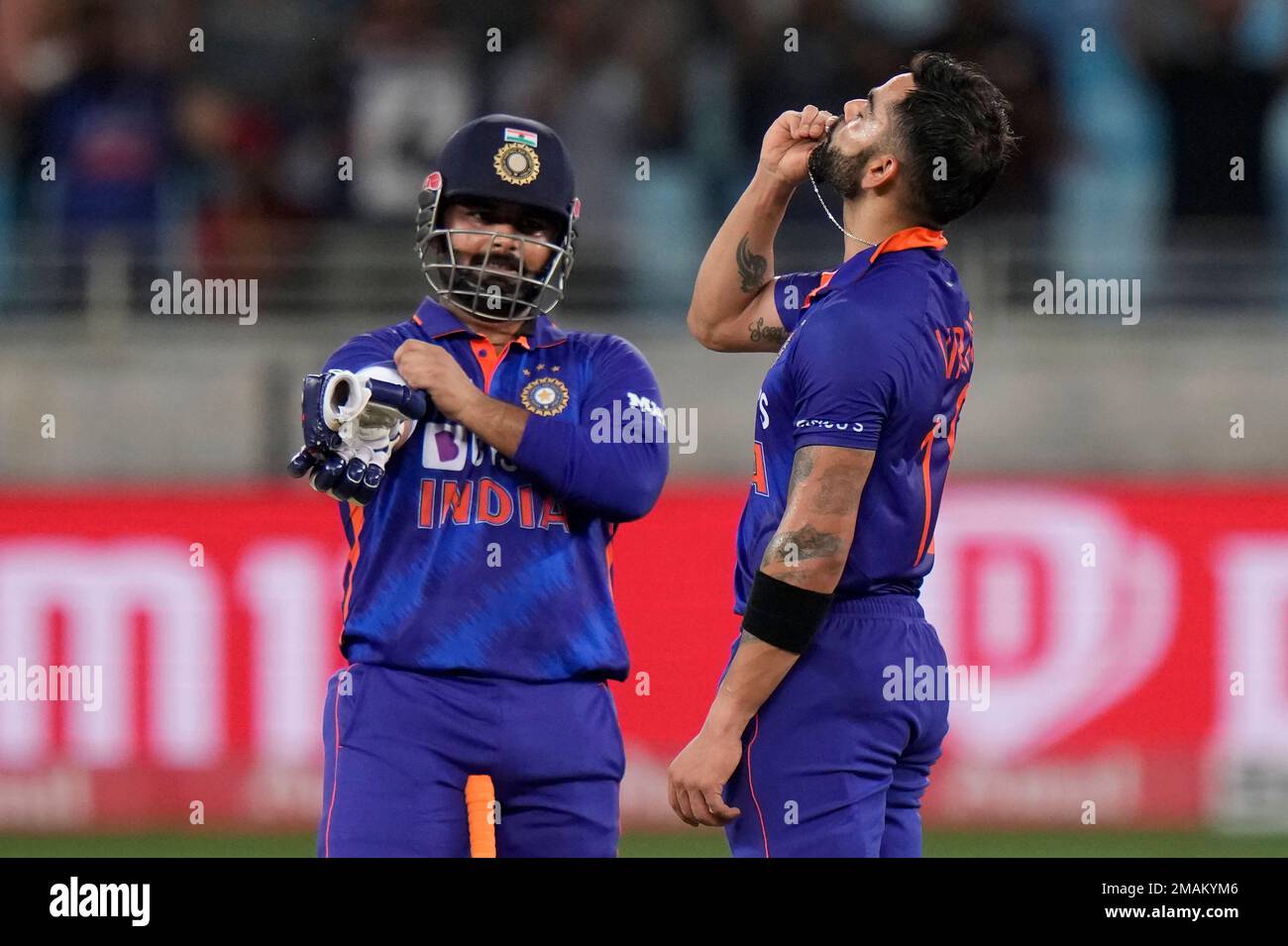 India's Virat Kohli, right, kisses the locket after scoring a century ...