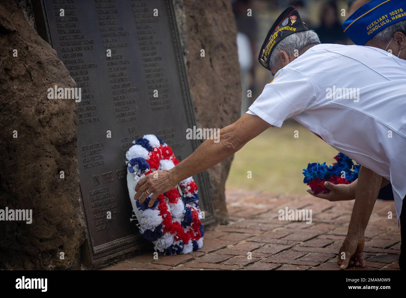 Veteran group leaders lay a wreath and lei on a monument in honor of ...