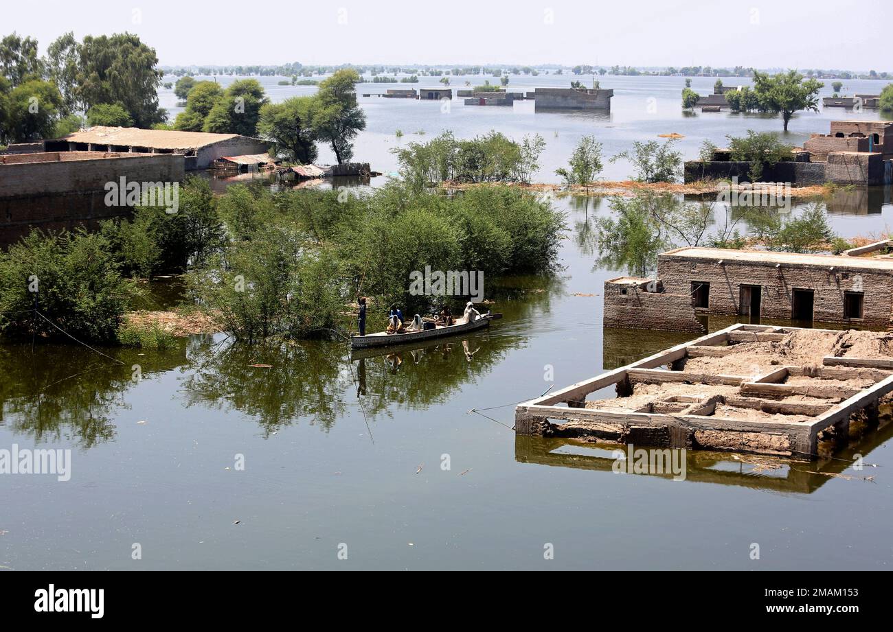People use a canoe to navigate floodwaters from monsoon rains in the ...