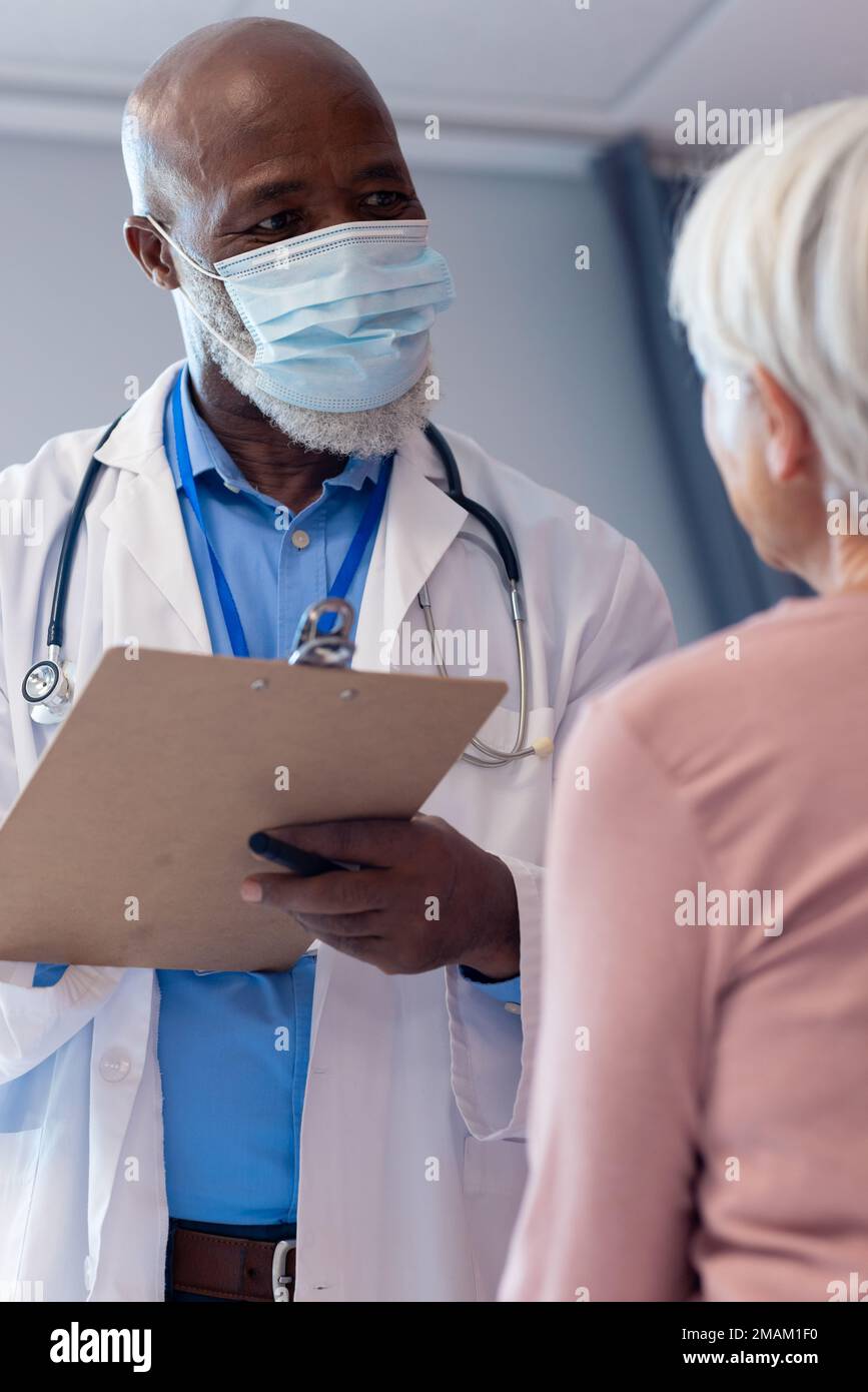 Doctor in mask talking senior hi-res stock photography and images - Alamy