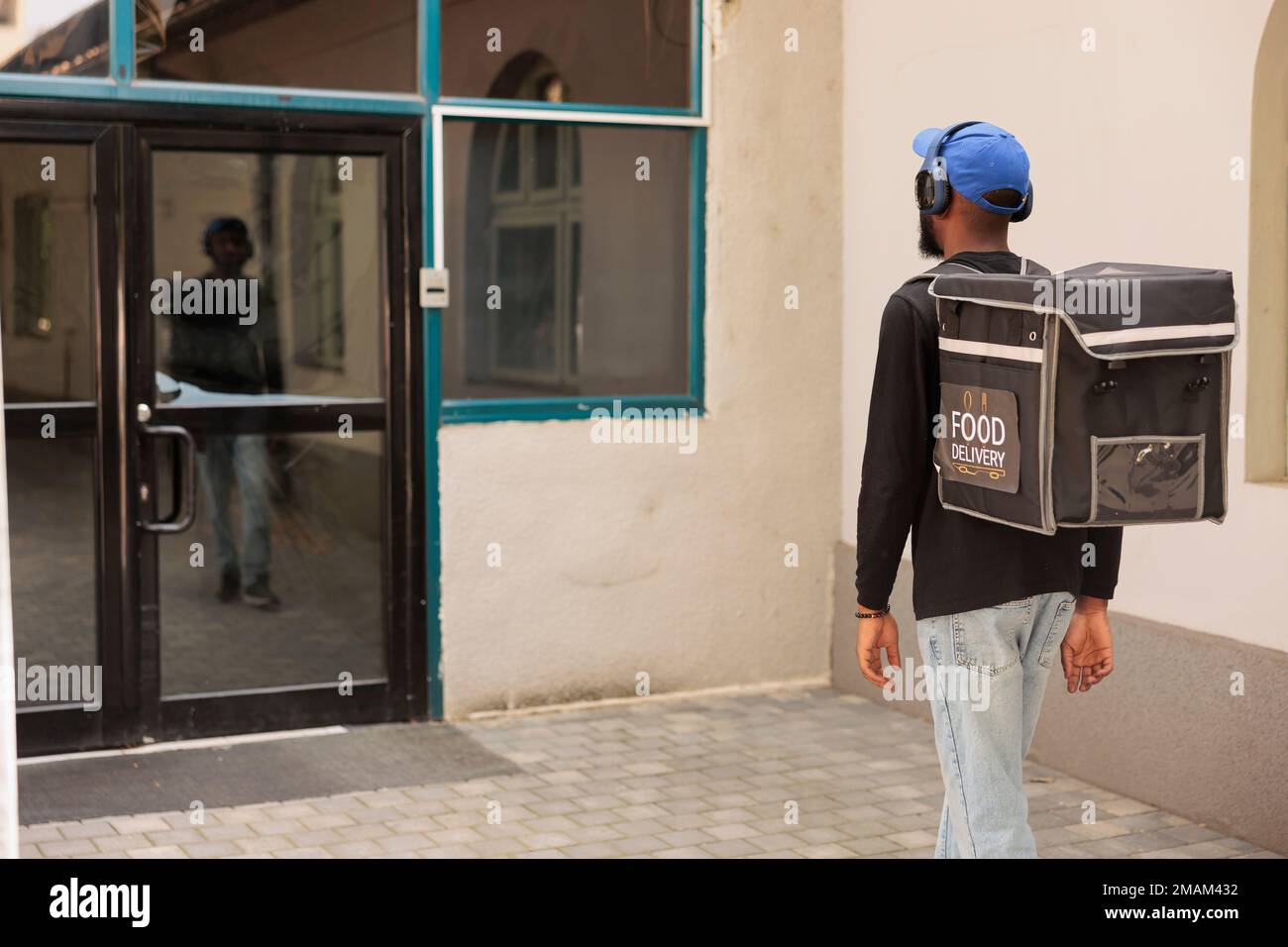 Food deliveryman going to office building entrance, waiting for ...