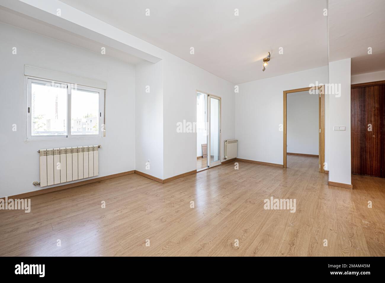 Living room of an empty house with oak wooden doors, exit to a terrace ...