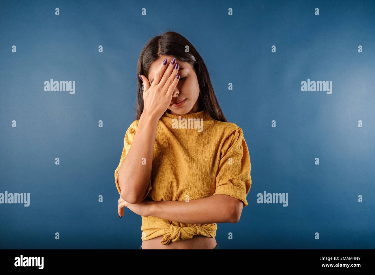 Portrait of young brown-haired woman isolated over blue background ...
