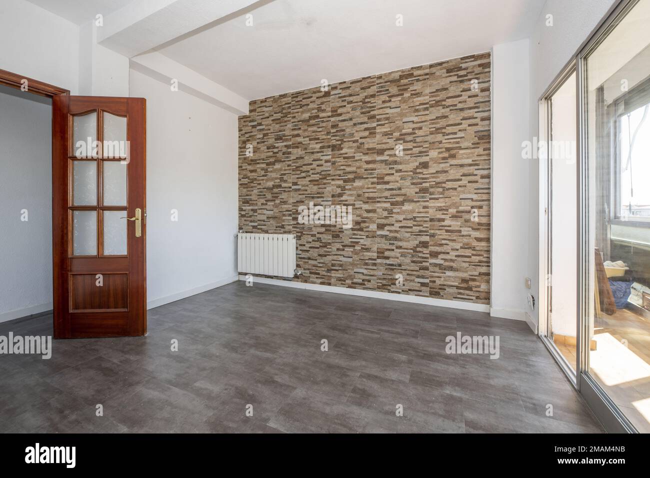 Empty living room with gray sintasol floors, exit to the terrace and a ...