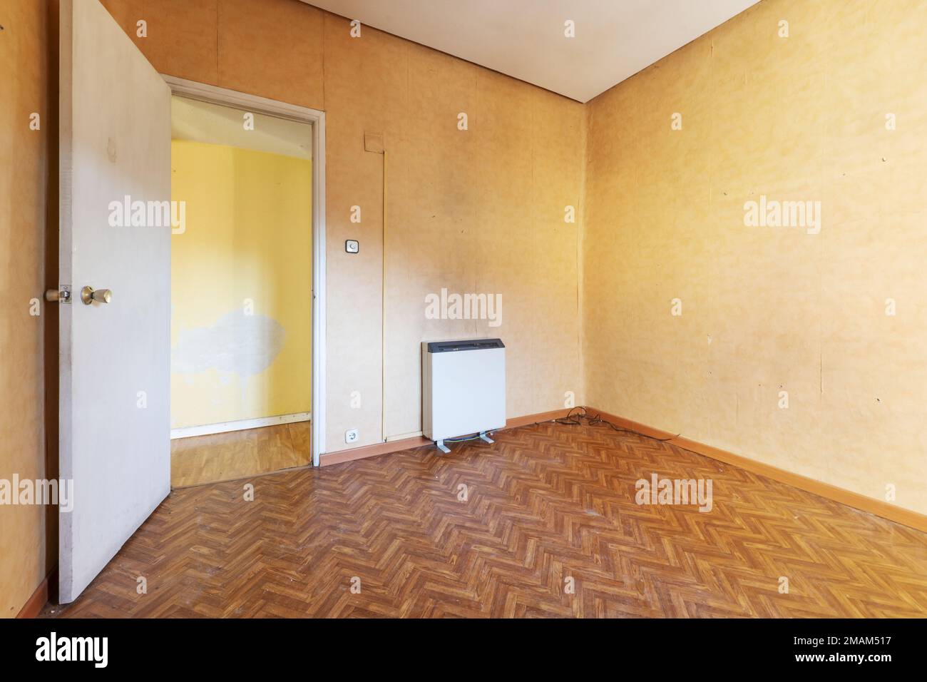 Empty and old room with wood-like sintasol floors, electric heat ...