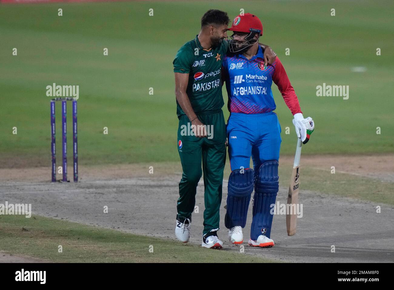 Pakistan's Haris Rauf, left, shares a light moment with Afghanistan's ...