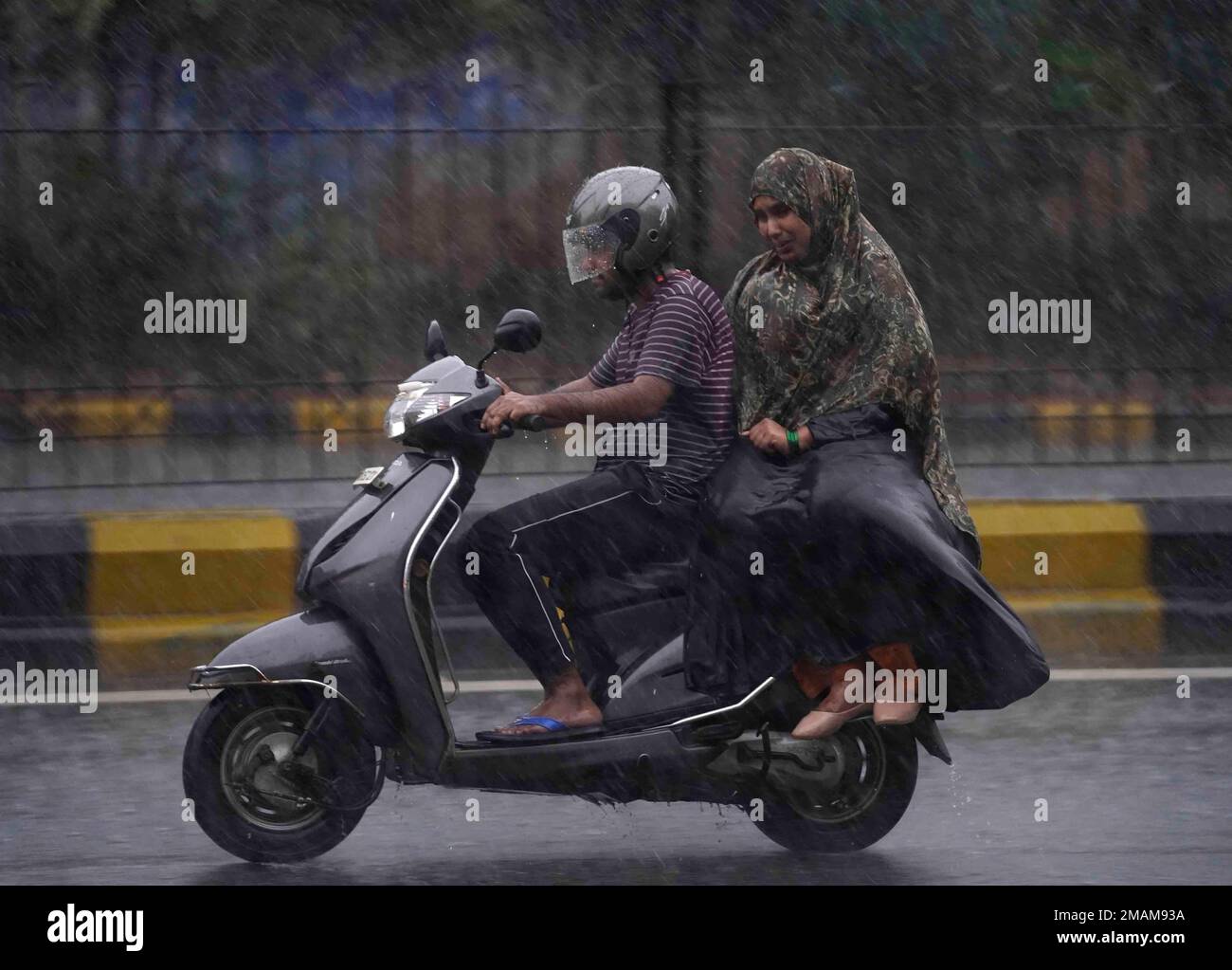 People ride a scooter in the rain in Hyderabad, India, Wednesday, Sept ...