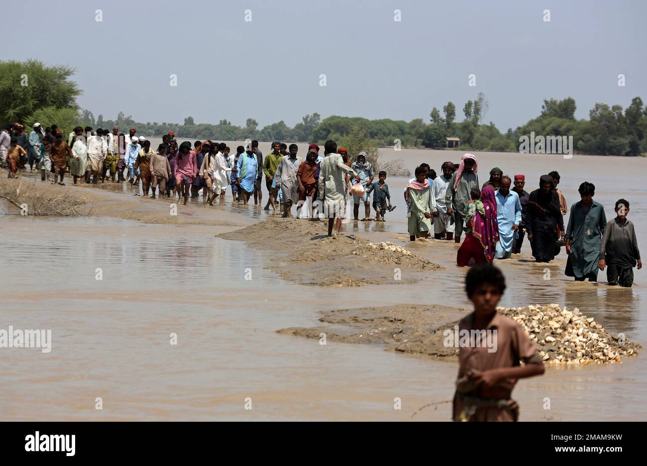 Victims of unprecedented flooding from monsoon rains line up to receive ...