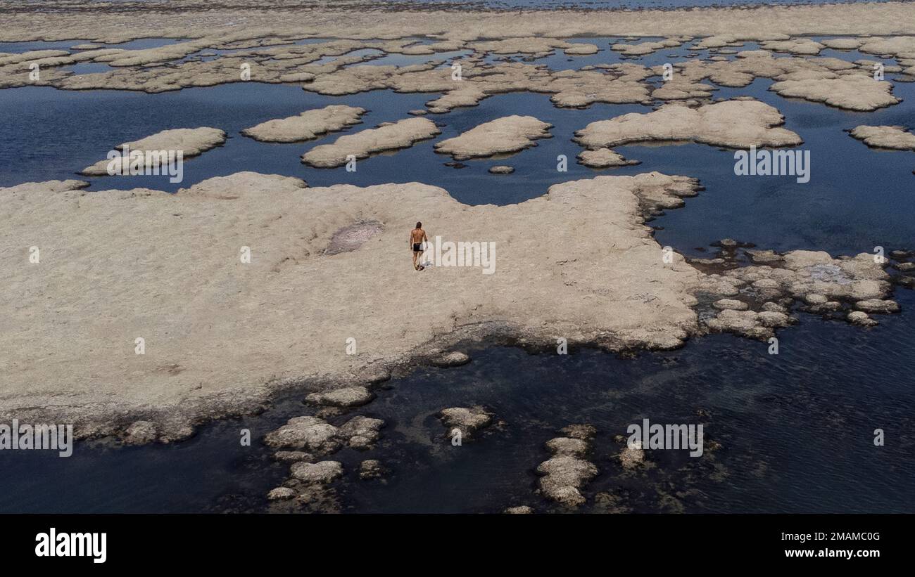 Olof Wood walks across reef-like structures called microbialites ...