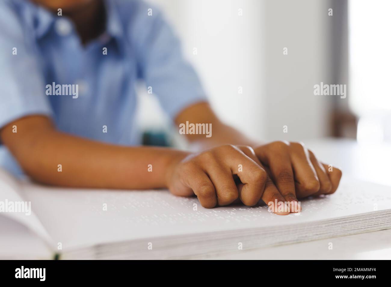 African american blind boy sitting at table, reading braille Stock ...