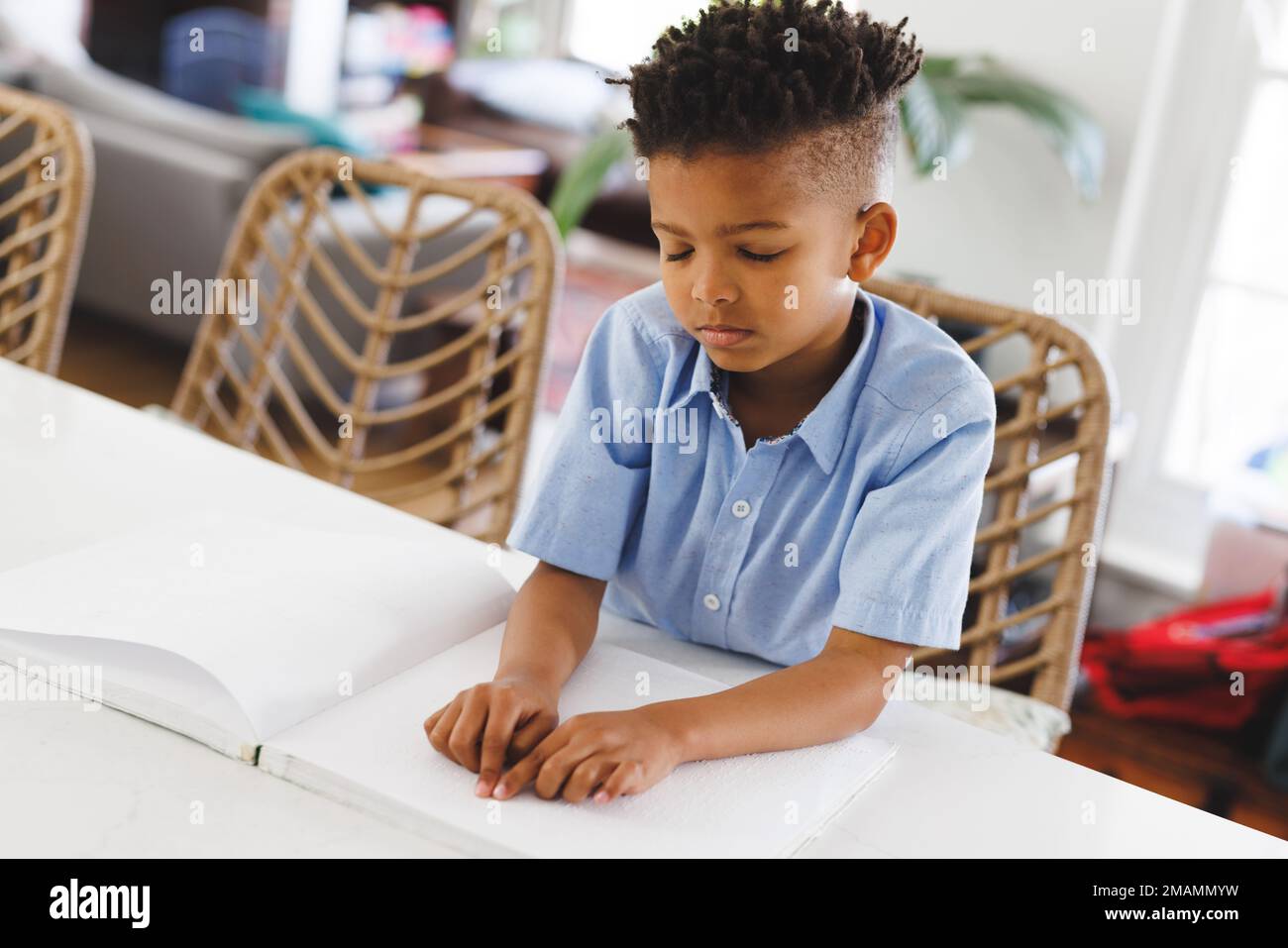 African american blind boy sitting at table, reading braille Stock ...