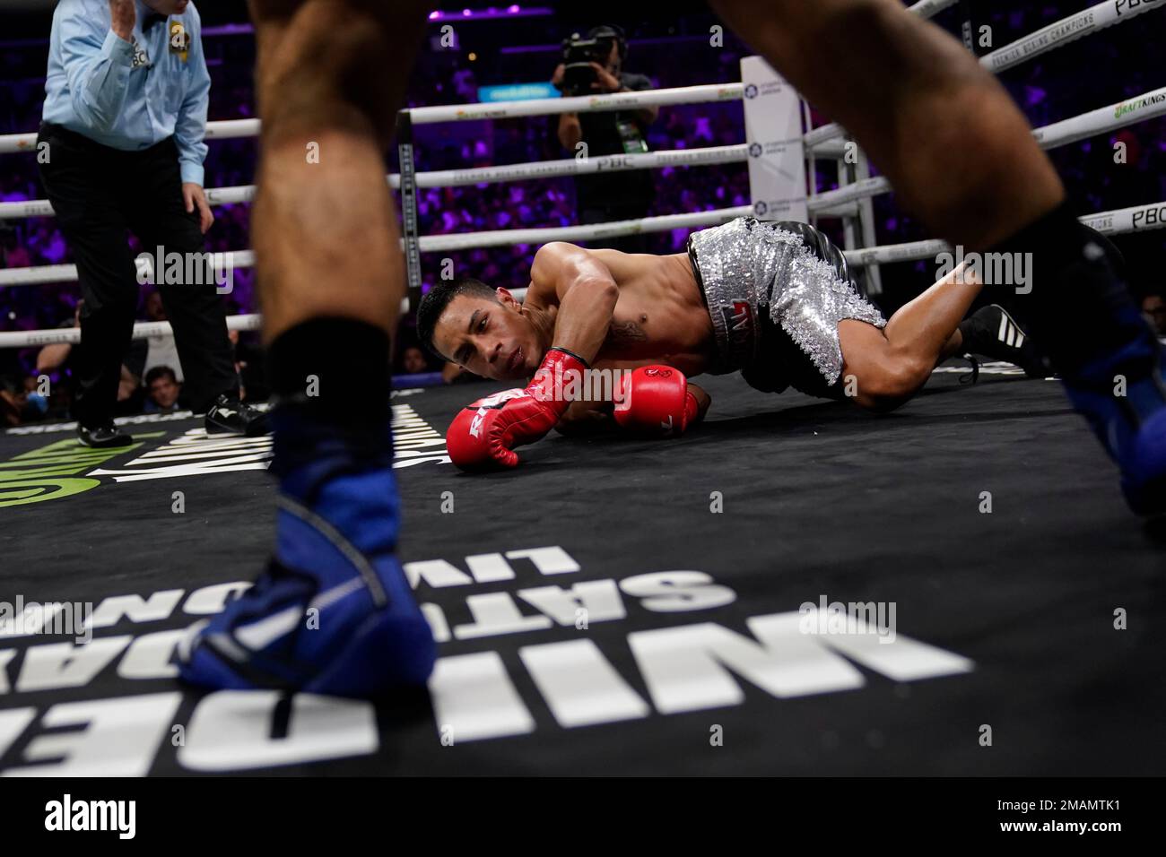 Eduardo Ramirez, center, is knocked down by Isaac Cruz in a WBC world ...