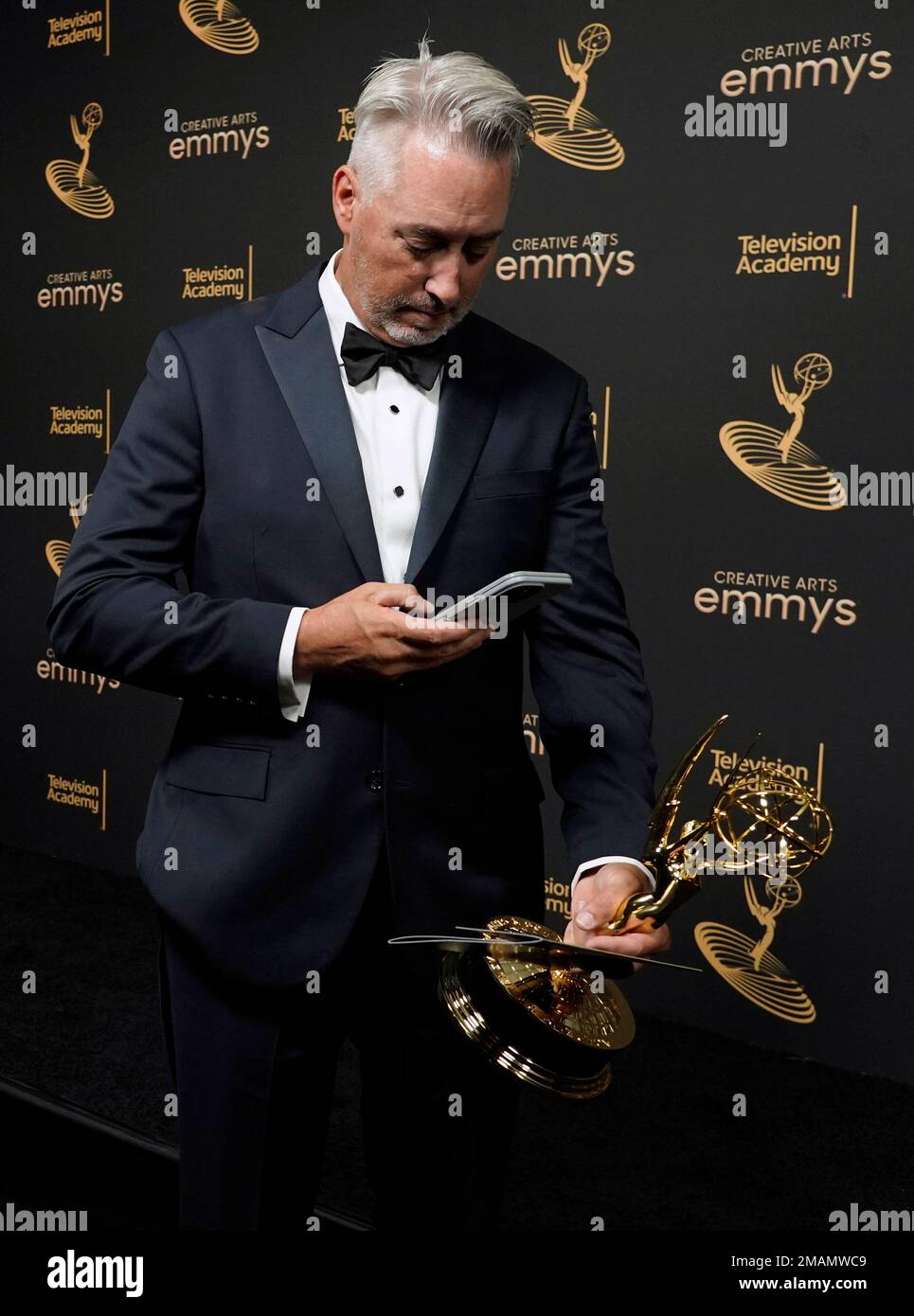Wade Allen takes photo of his award in the press room with the award ...