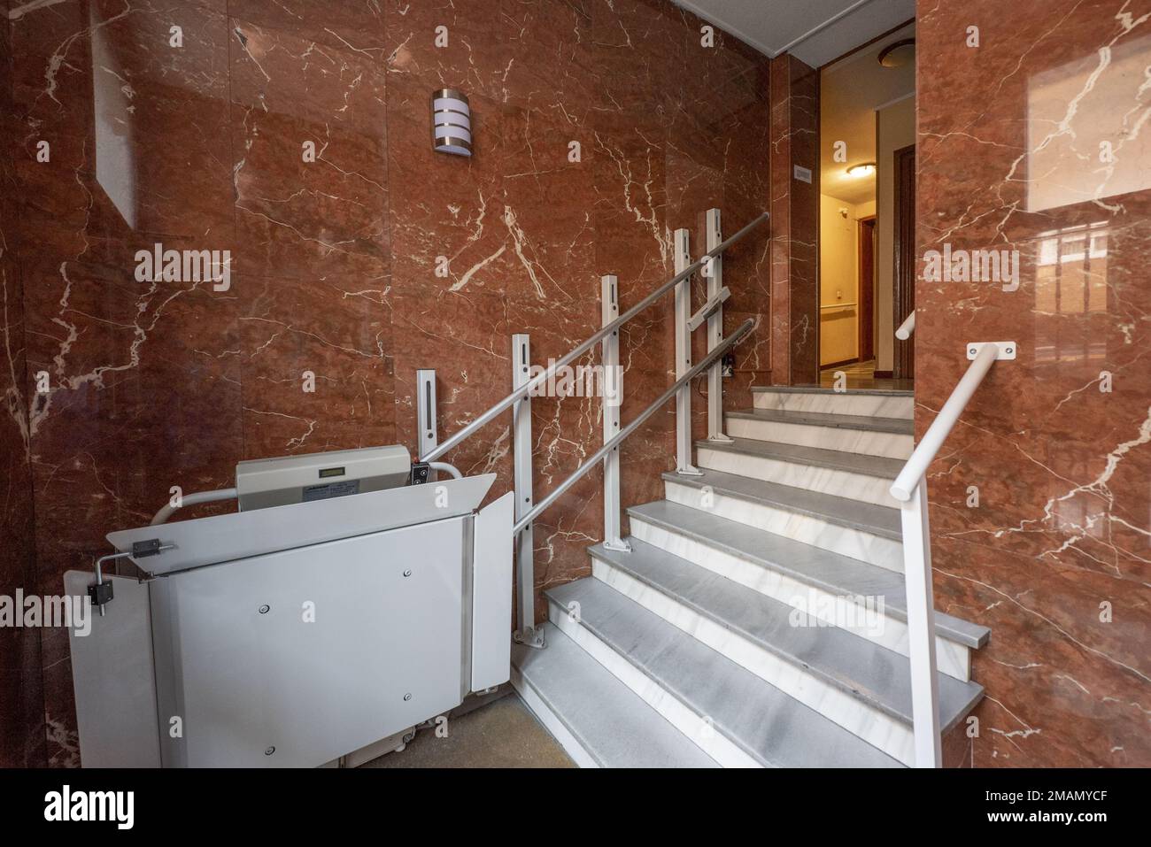Portal with reddish marble tiles, white marble stairs and electric ramp ...