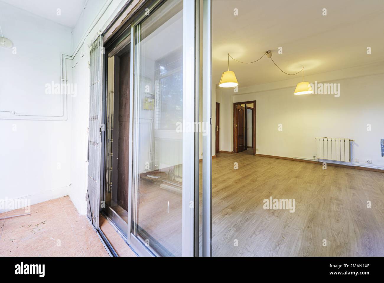 Empty living room with oak flooring with access to the terrace and ...