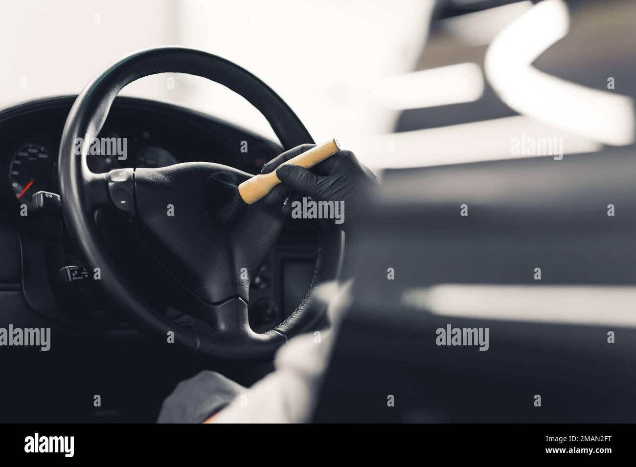 Person cleaning steering wheel with a brush. Car detailing process ...
