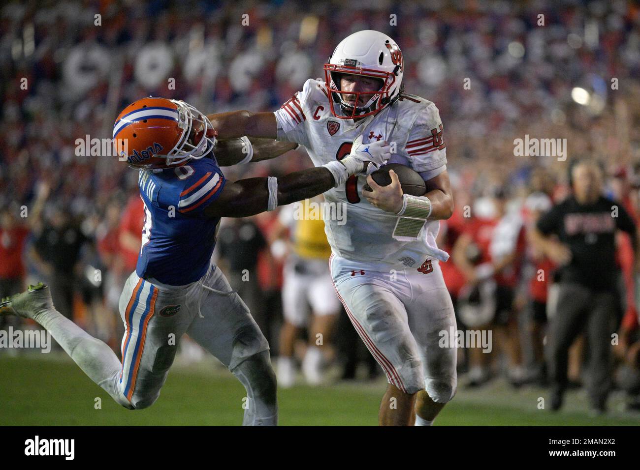 Utah quarterback Cameron Rising (7) stiff arms Florida safety Trey Dean ...