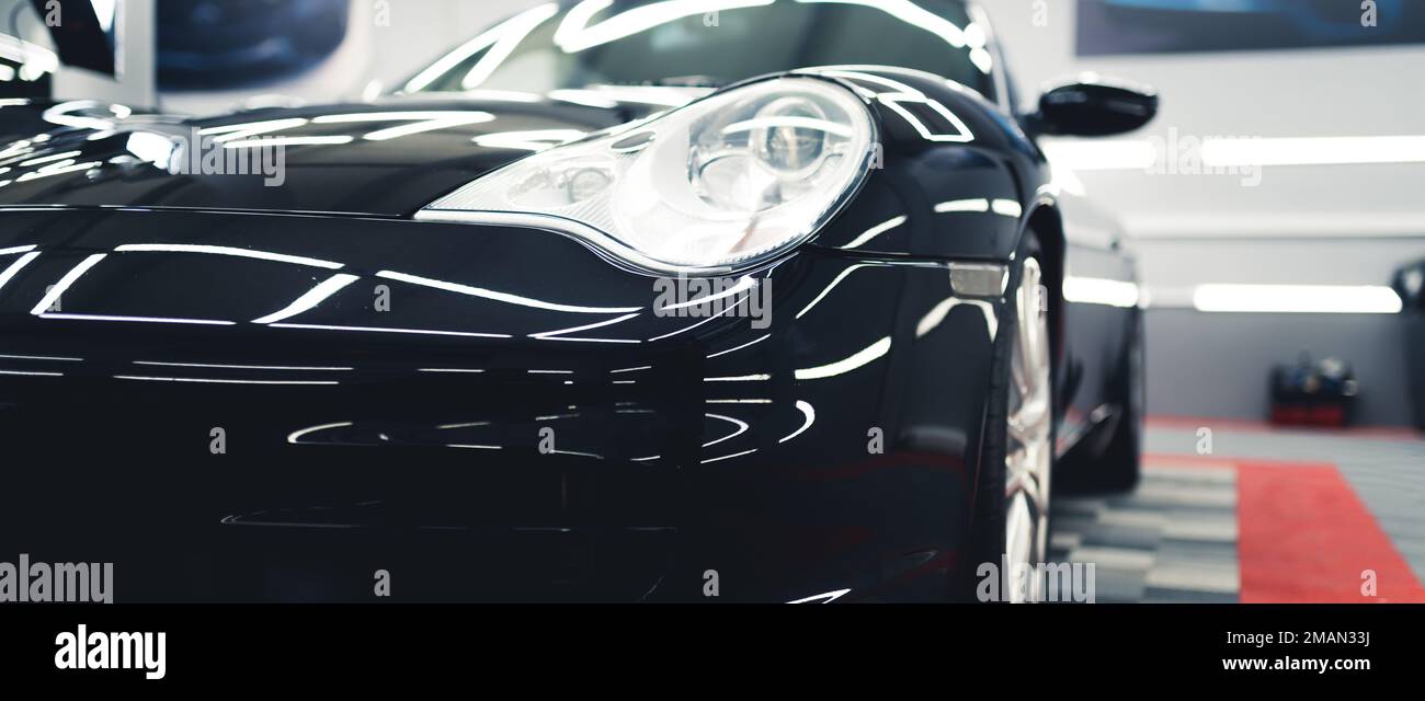 Front of sports car closeup. Indoor shot of black shiny sports vehicle ...