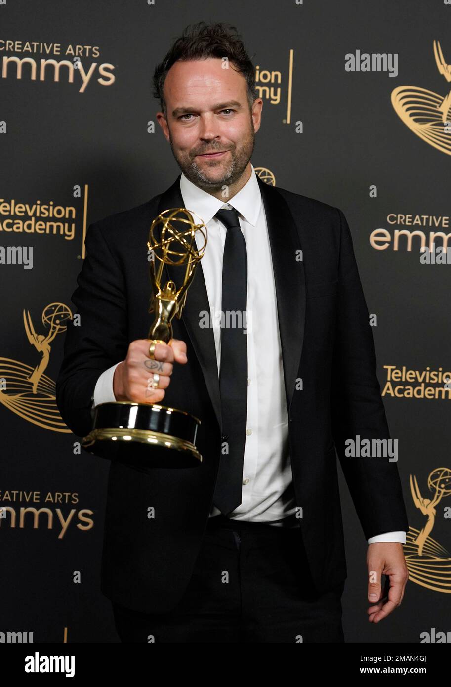 Paul Dugdale poses in the press room with the award for outstanding ...