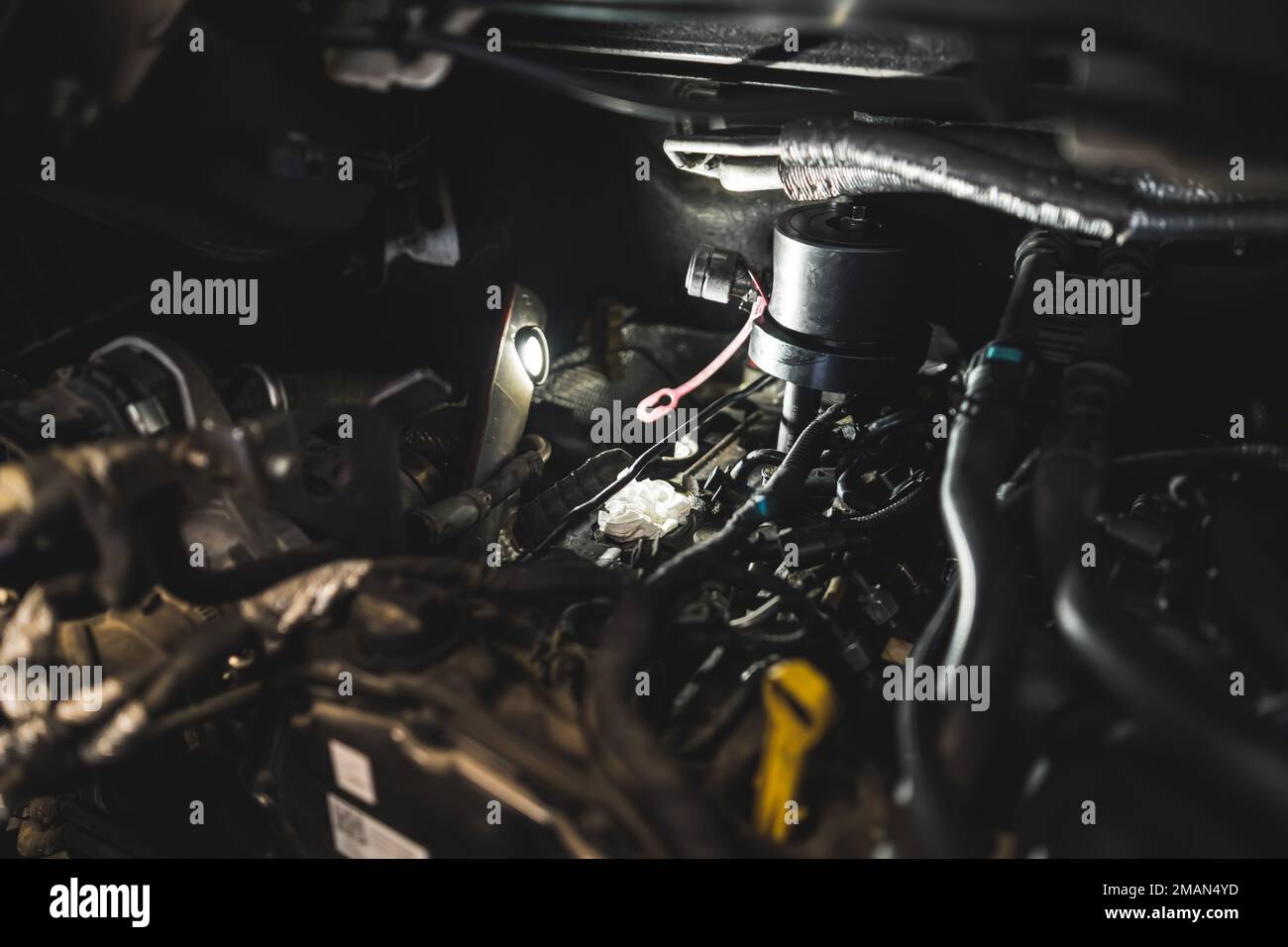 Mechanic removes a stuck injector in a diesel engine with the press in ...