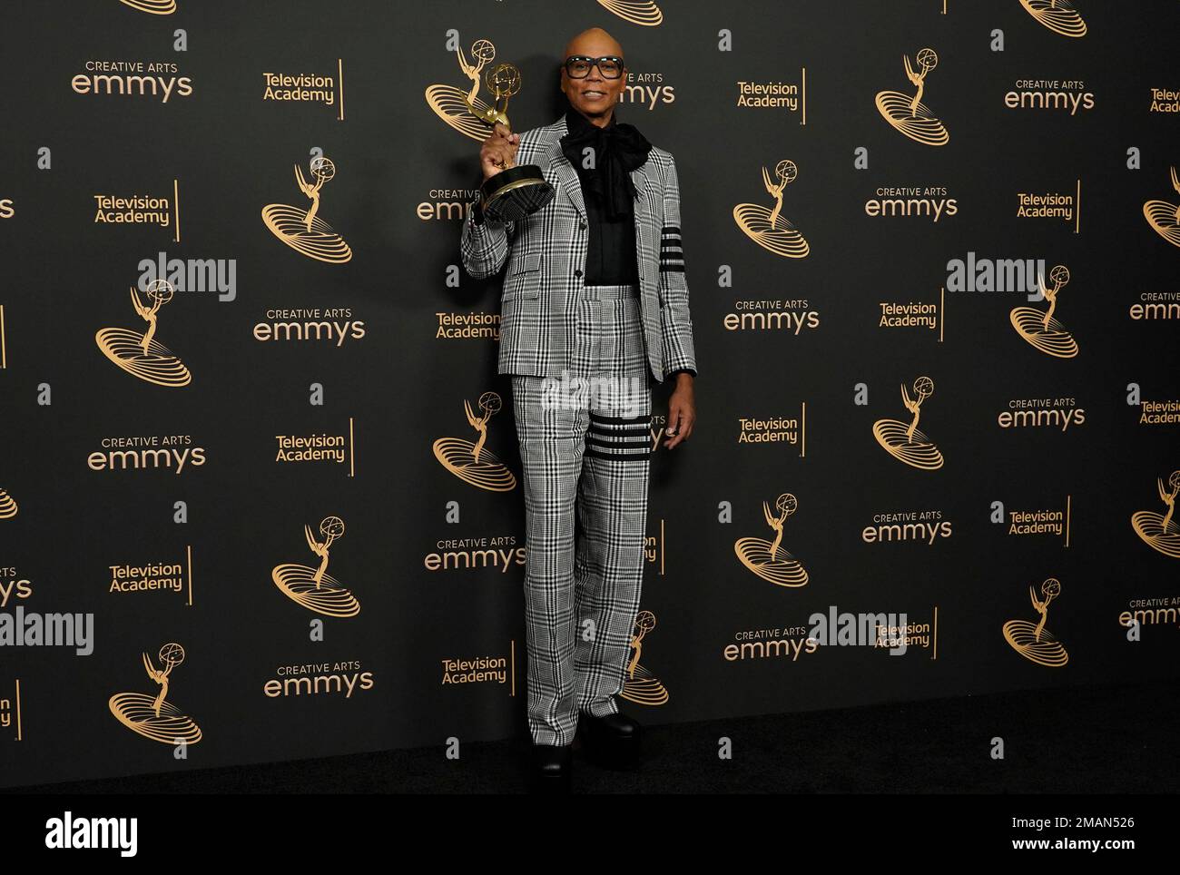 RuPaul poses in the press room with the award for outstanding host for ...