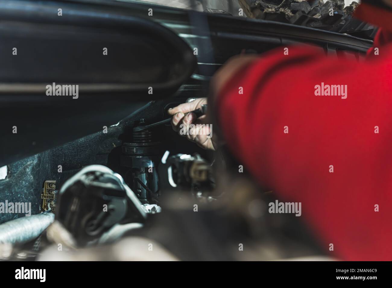 Mechanic removes a stuck injector in a diesel engine with the press in ...