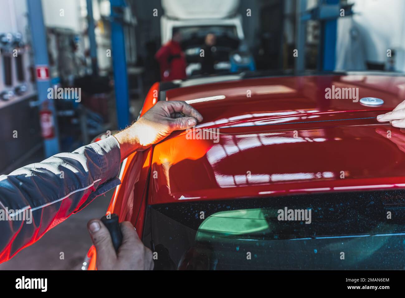 Mechanic customizes car removing spoiler using cutting cord in an auto ...
