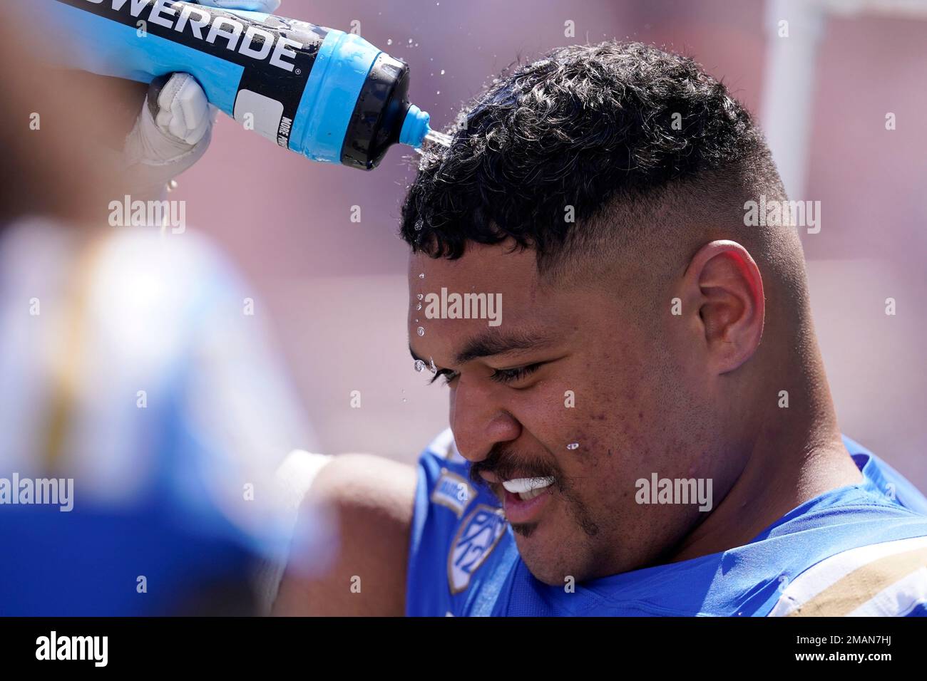 UCLA offensive lineman Atonio Mafi sprays water on his head during the ...