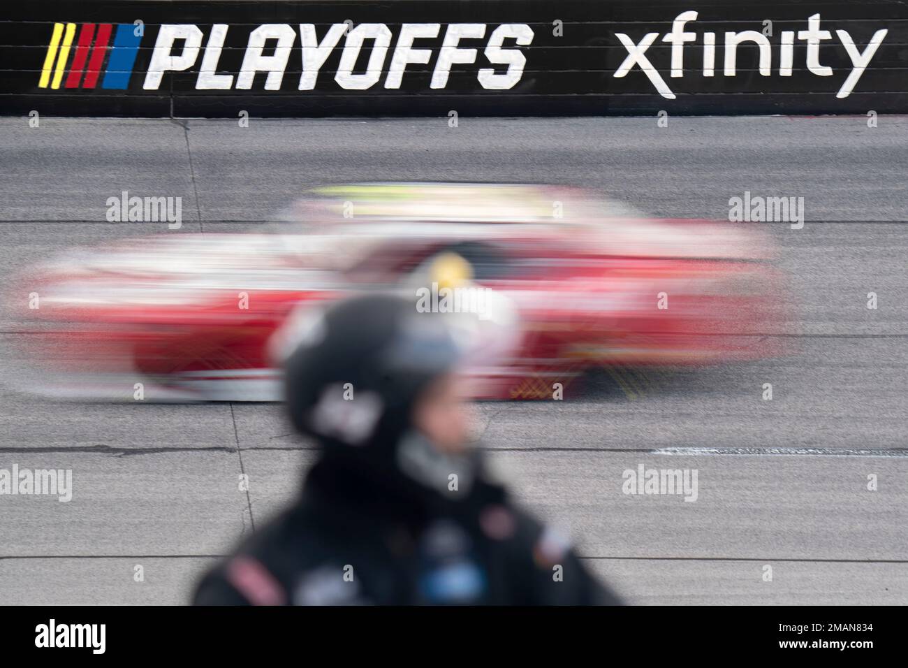 A pit crew member watches drivers compete during a NASCAR Xfinity ...