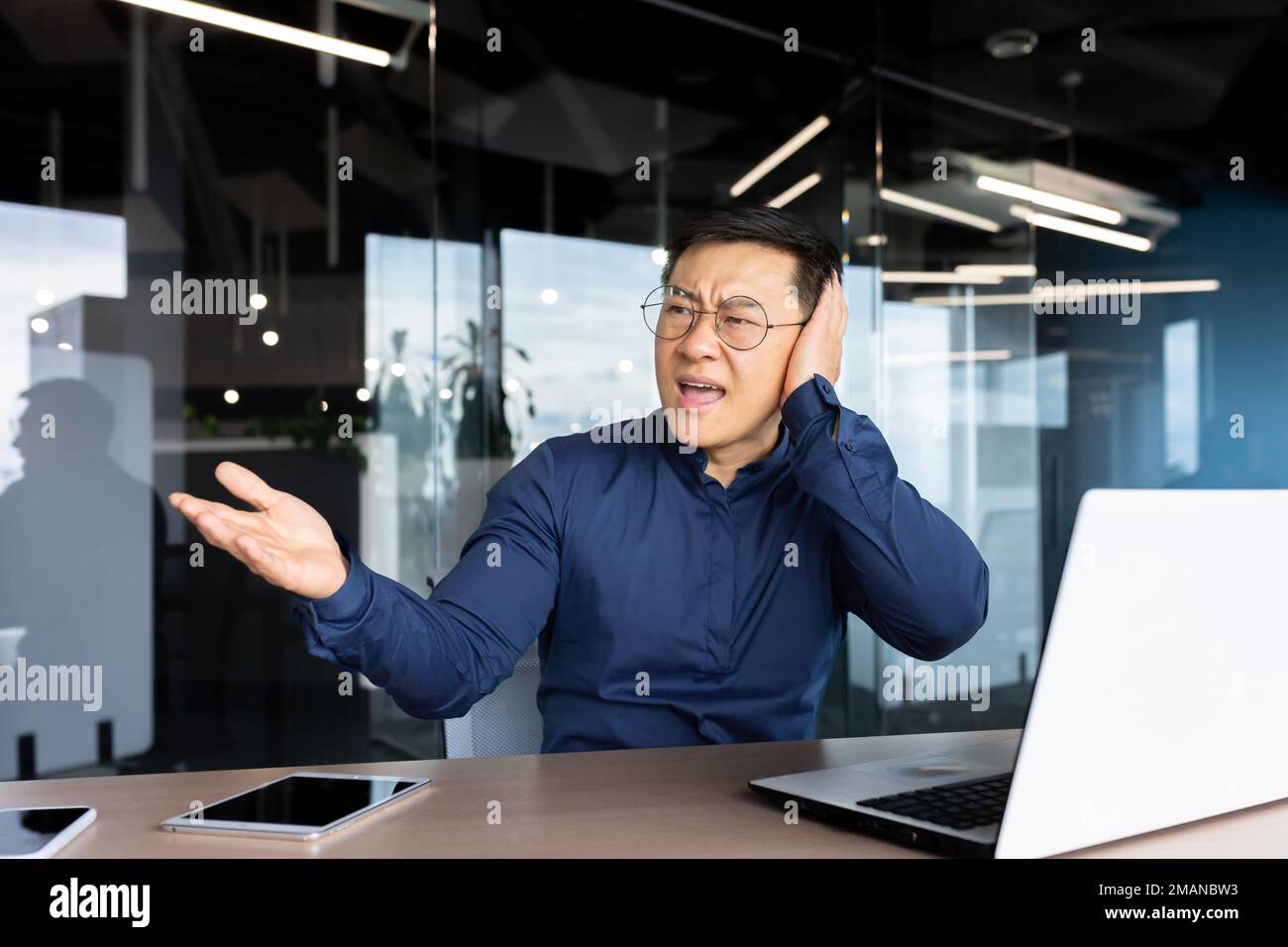 Excessive noise in the office, a businessman tries to be quiet, a man ...