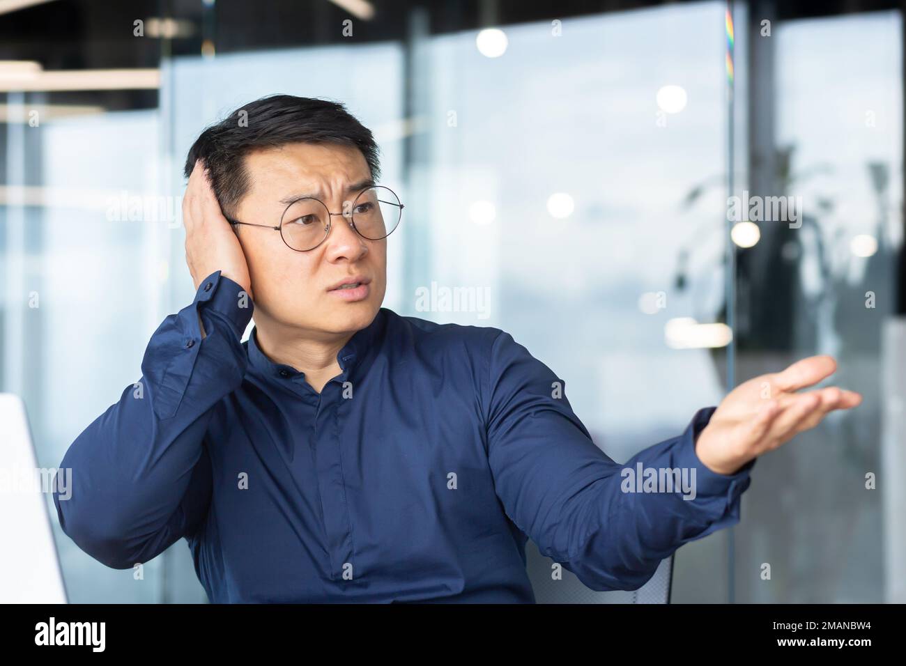 Excessive noise in the office, a businessman tries to be quiet, a man ...