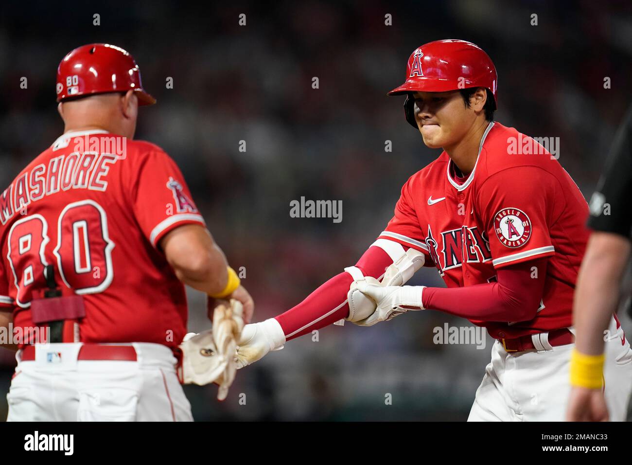 Los Angeles Angels designated hitter Shohei Ohtani, right, changes his ...