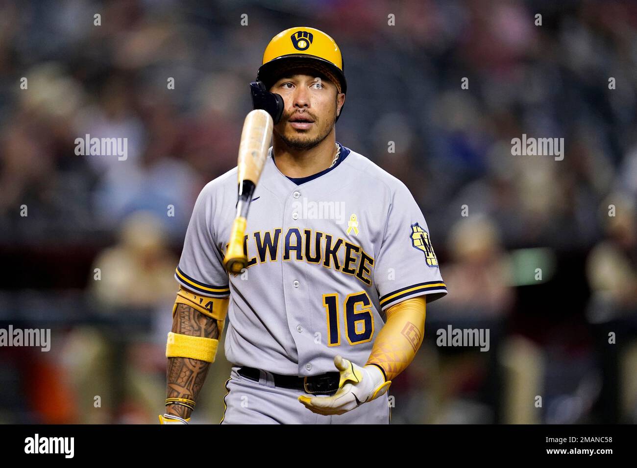 Milwaukee Brewers' Kolten Wong flips his bat after striking out against ...